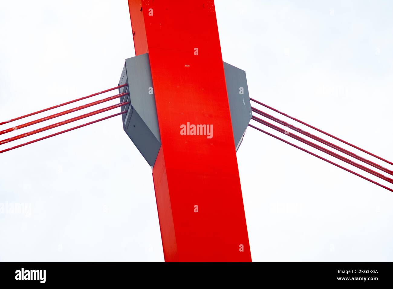 Red metal strings attached to the pole of a cable-stayed bridge Stock ...