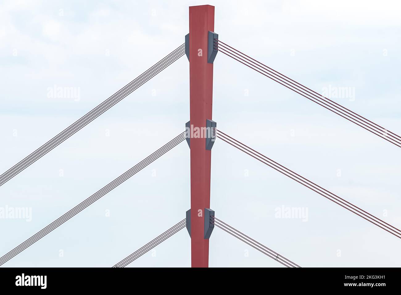 Red metal strings attached to the pole of a cable-stayed bridge Stock ...