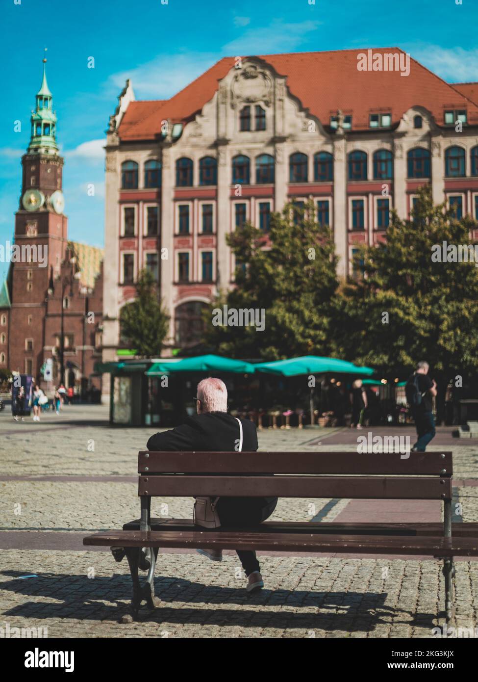woman sitting on the bench in city square Stock Photo - Alamy