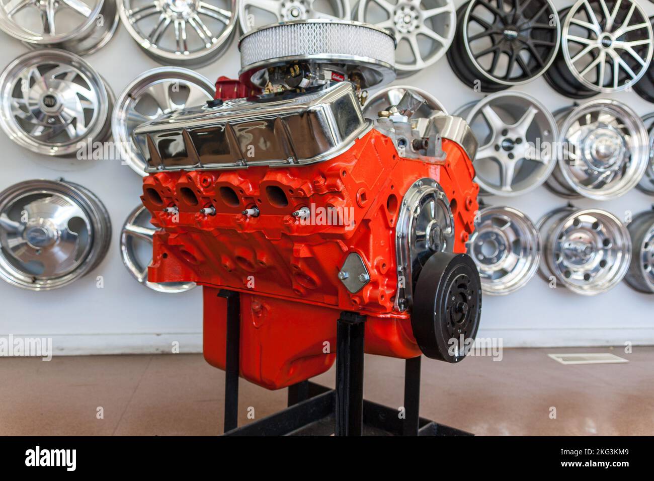 The view of a red vehicle engine with rims displayed on the background ...