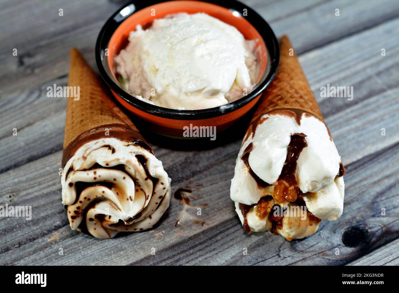 Ice cream vanilla cones with topping of chocolate and caramel sauce and ...