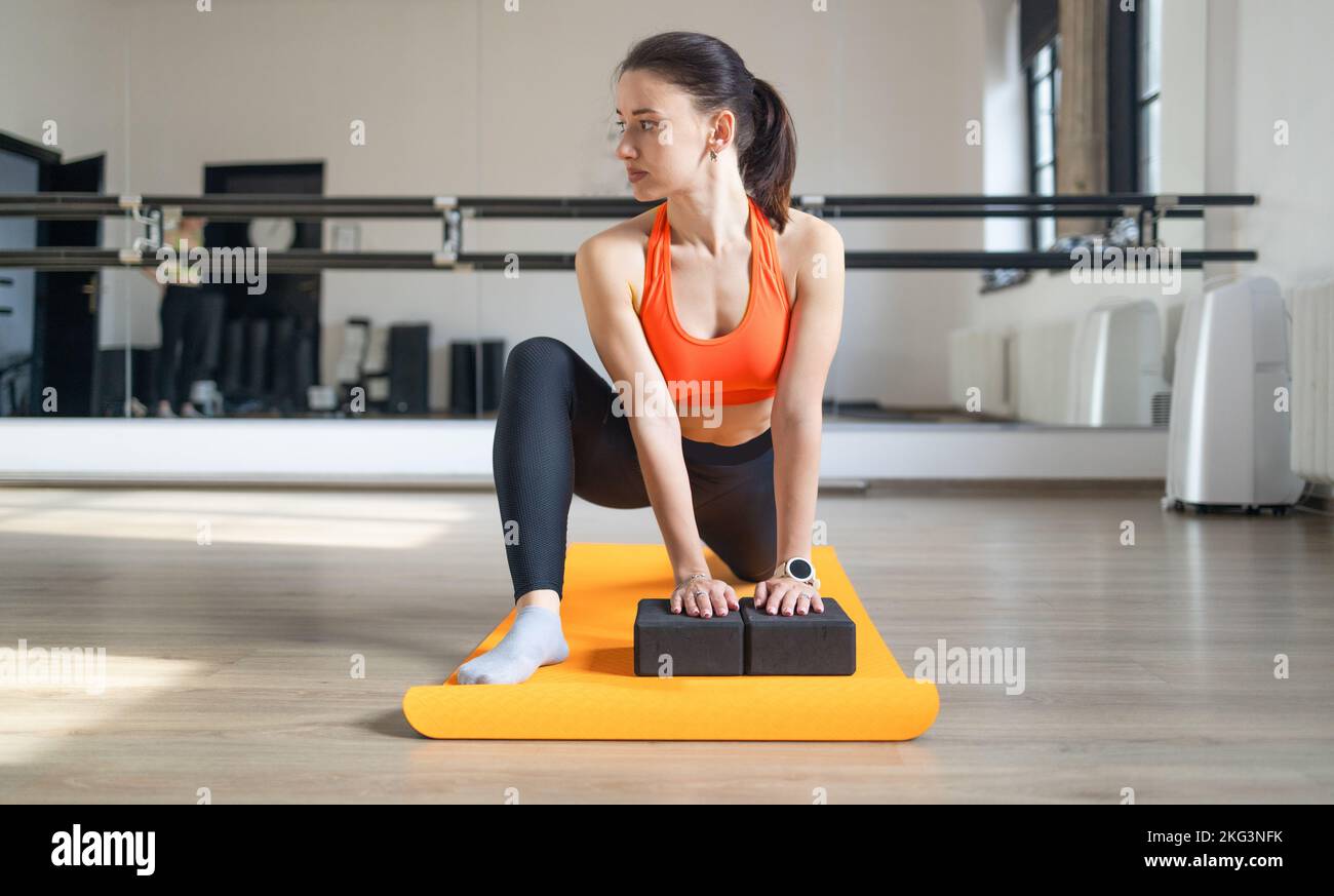 Yoga Stretch. Fool body portrait of a cheerful athletic woman in orange ...