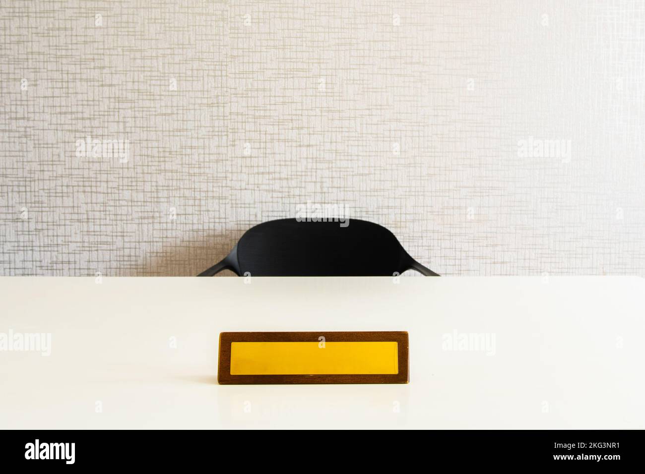 Empty name space on yellow office plate on white table with chair ...