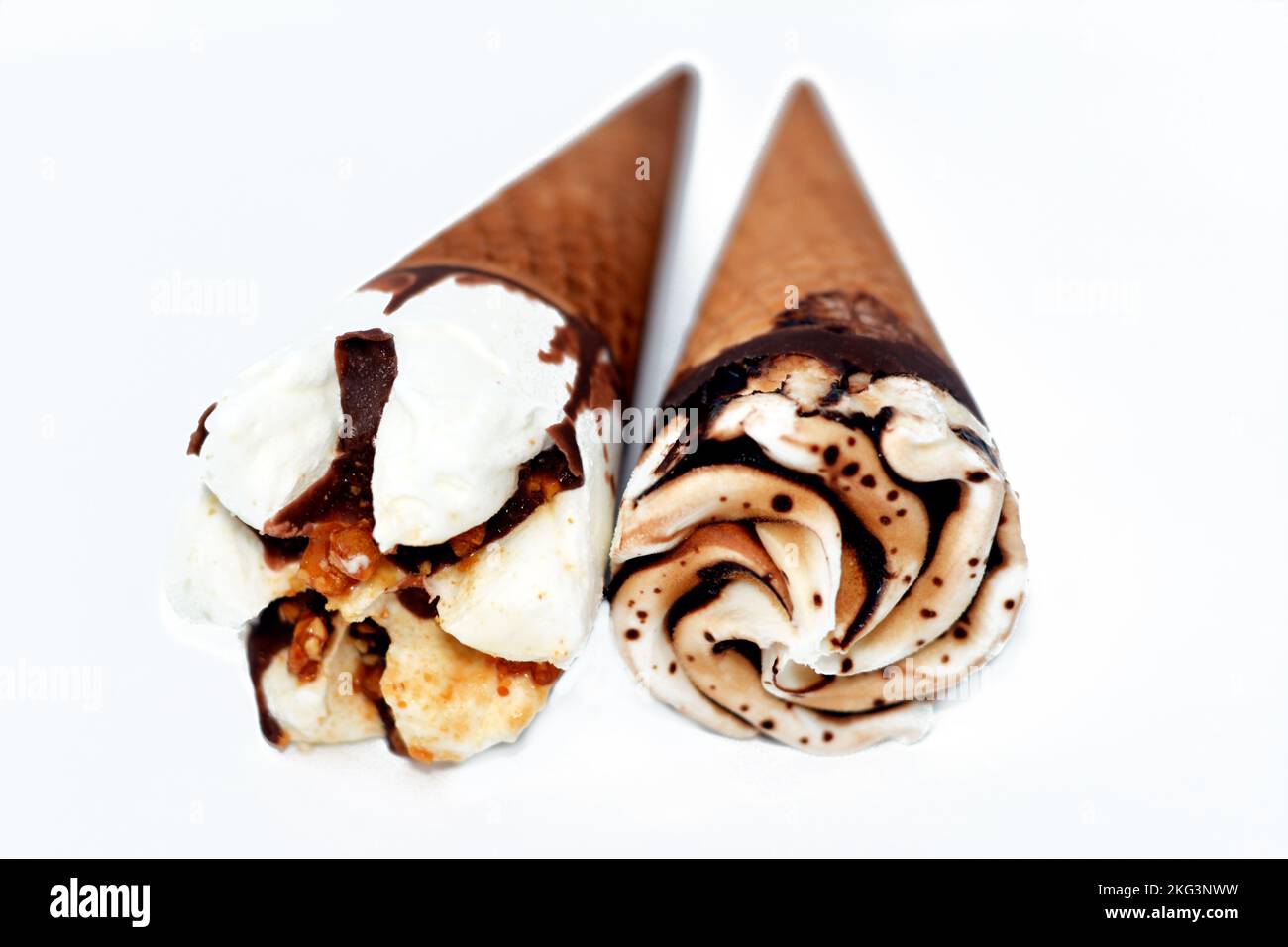 Ice cream vanilla cones with topping of chocolate and caramel sauce and nuts in a crispy wafer ...
