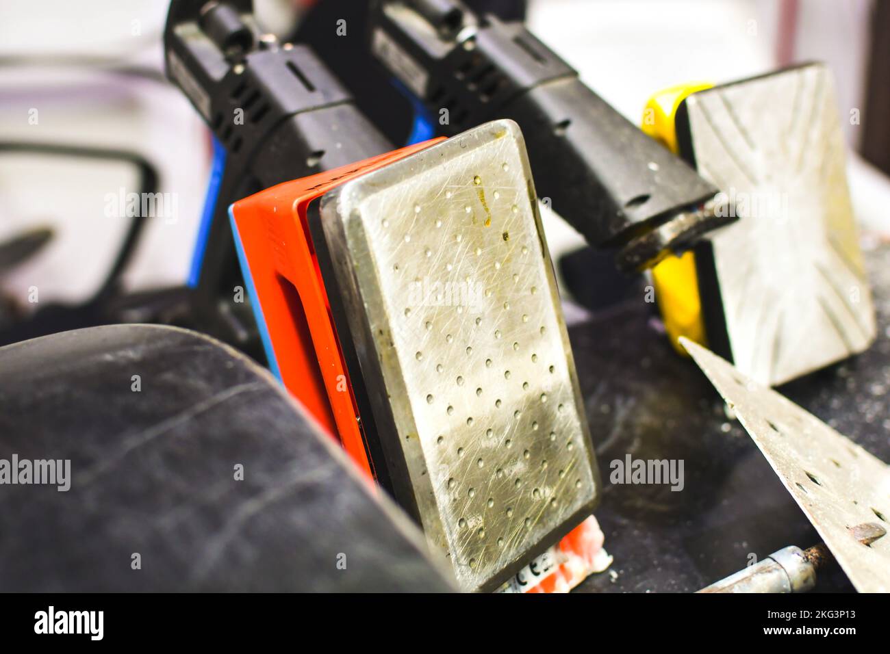 Close up focus on red wax iron surface in ski repair shop. Step by step ...