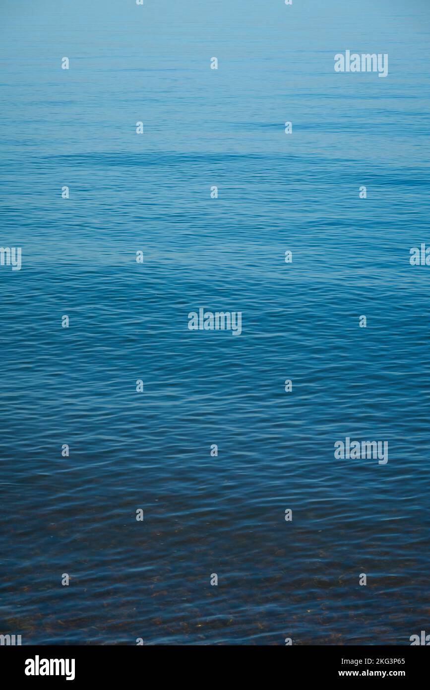A vertical shot of the shades of blue on the surface of blue water ...