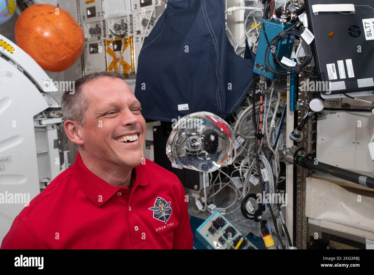 NASA astronaut Bob Hines observes the dynamics of a free-floating water ...