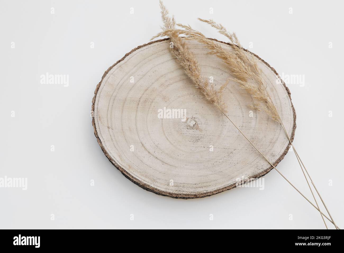 Natural still life. Wooden cutting board, timber with dry grass ...