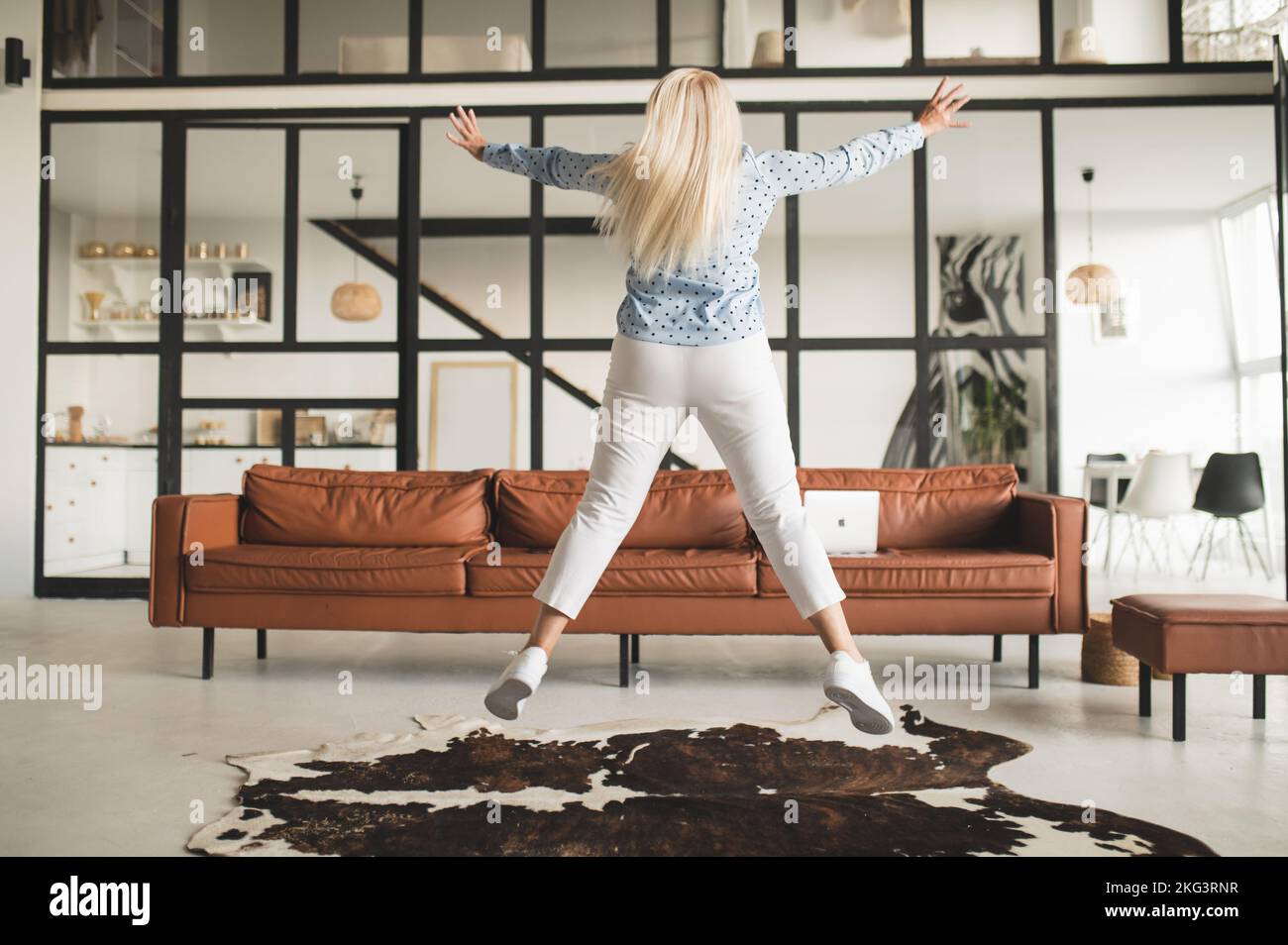 Blonde woman feeling excited and looking energized Stock Photo - Alamy
