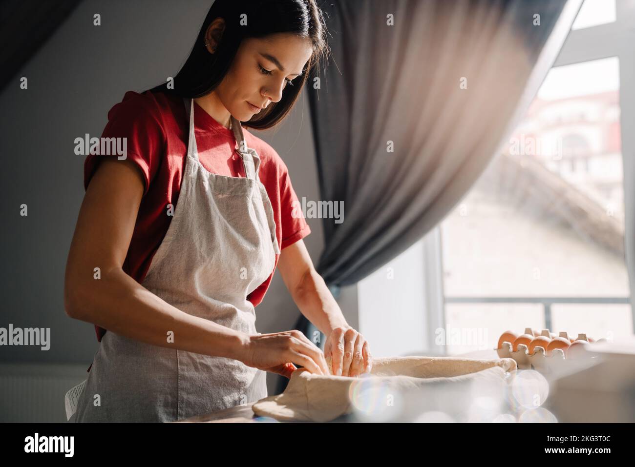 Young hispanic woman wearing apron making pie in kitchen at home Stock ...