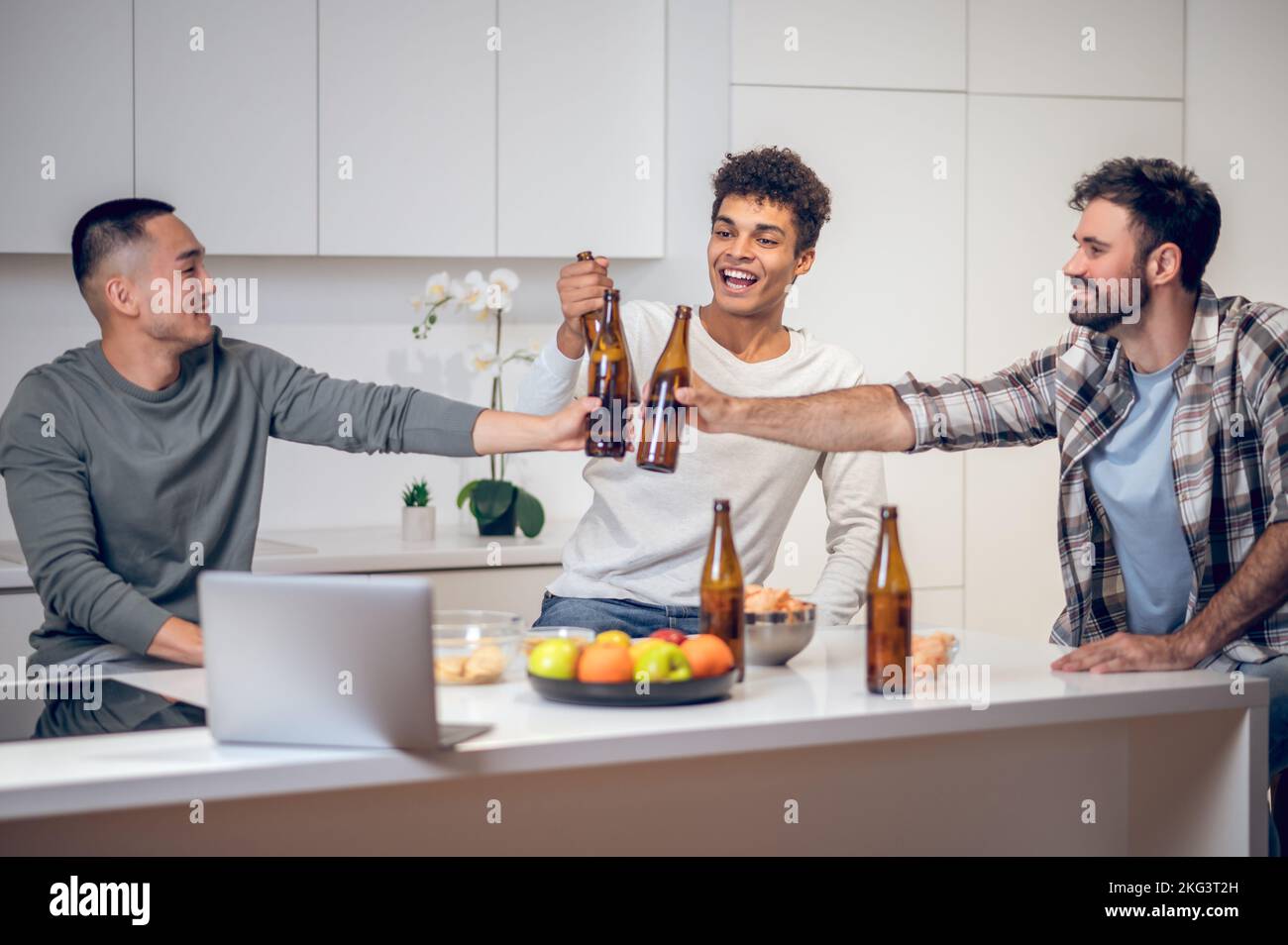 Men drinking an alcoholic drink in the kitchen Stock Photo - Alamy