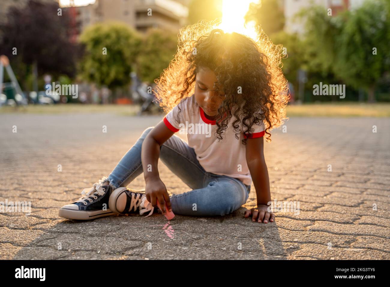 Child involved in a creative outdoor activity Stock Photo - Alamy