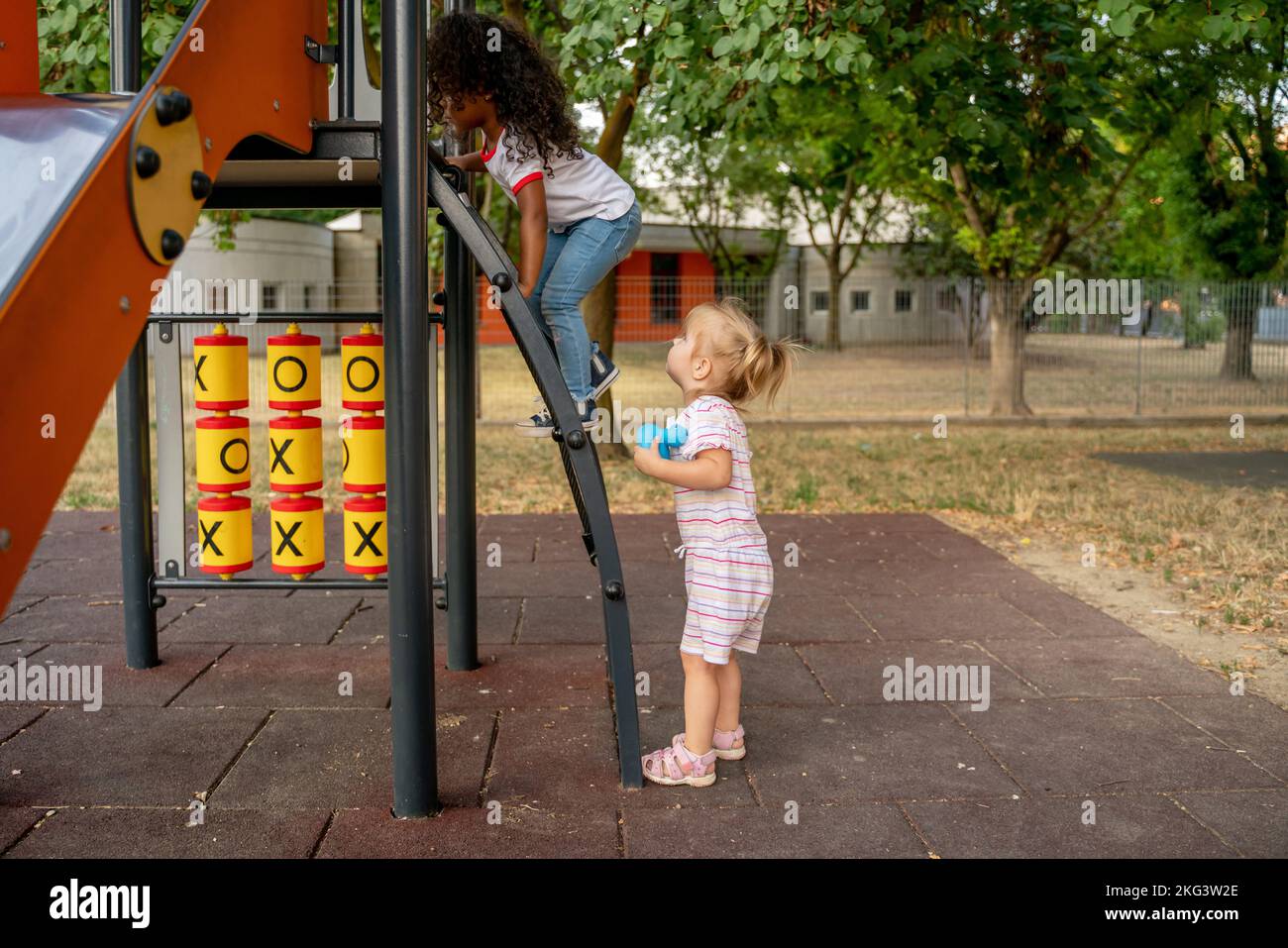 Two kids playing on the playground outdoors Stock Photo - Alamy