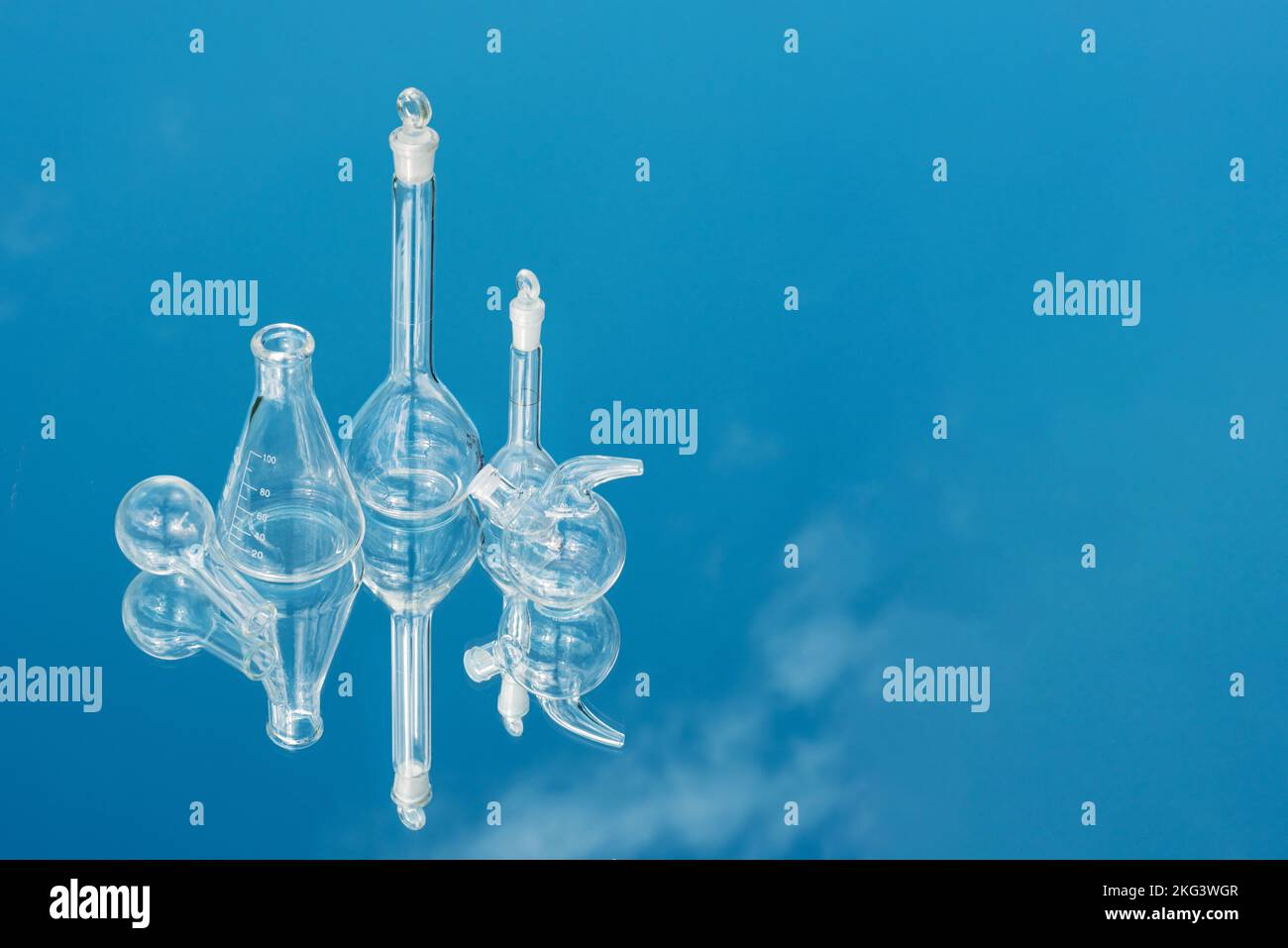 Various laboratory glassware on a mirror background with sky reflection ...
