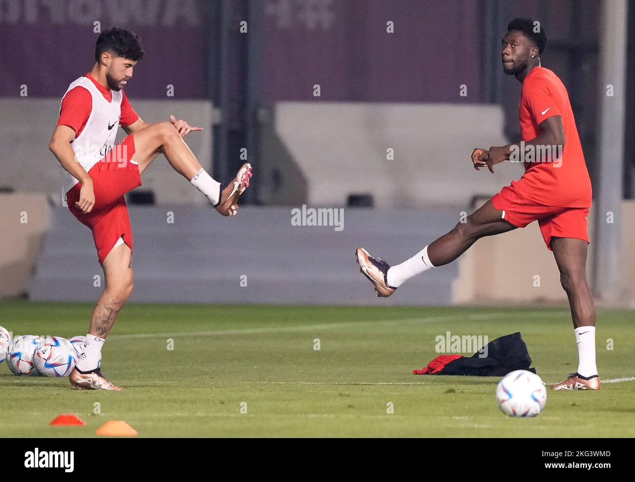 Canada forward Alphonso Davies, right, stretches his leg next to ...