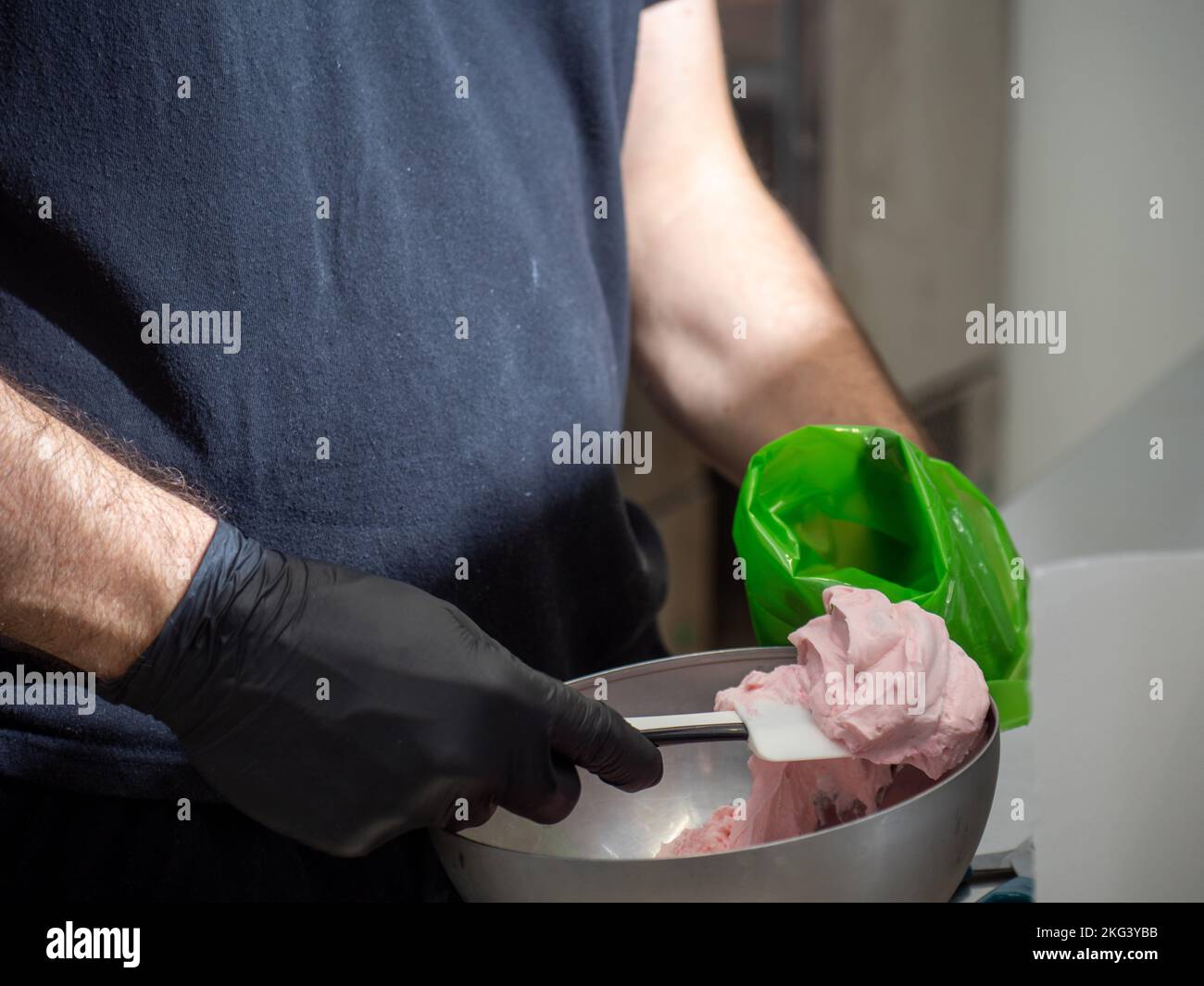 chef using using piping bag pink butter cream filling to decorate ...