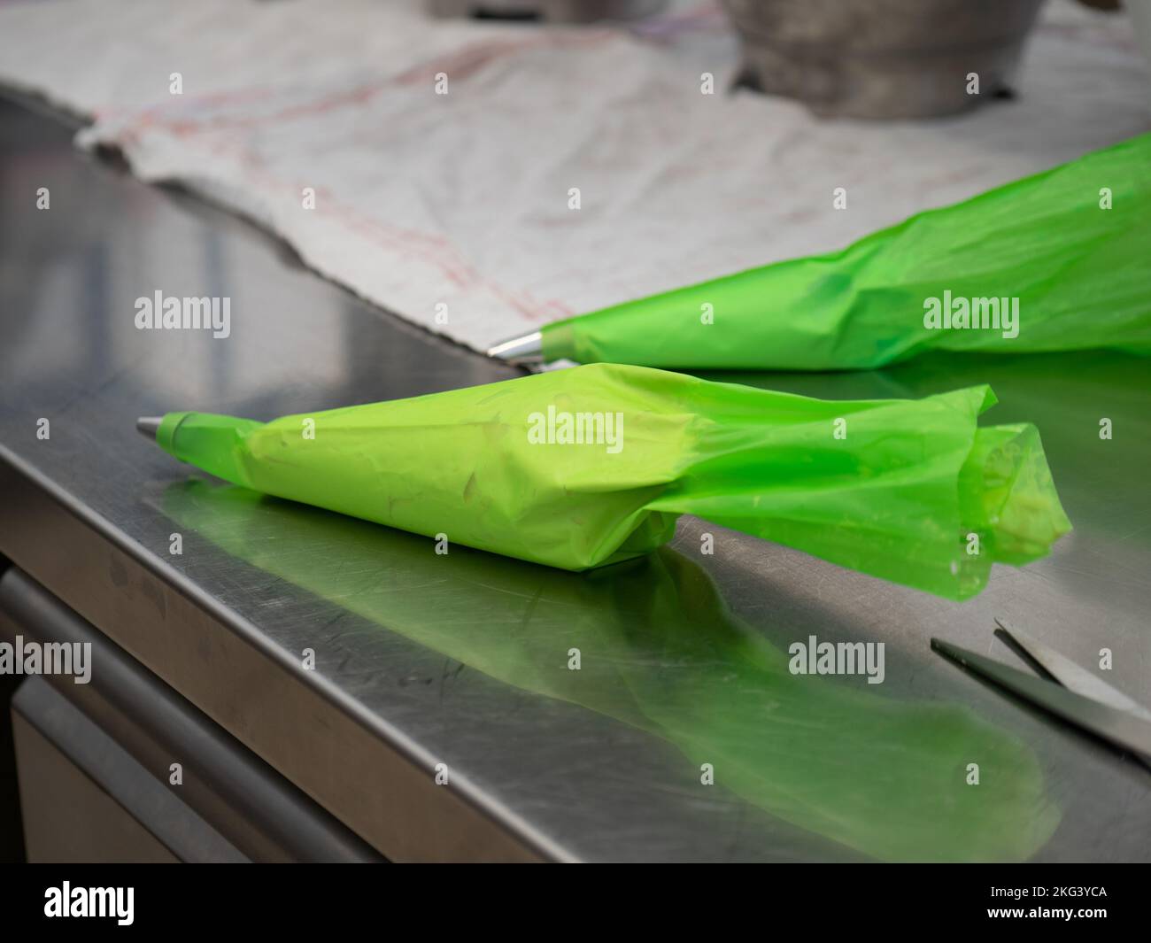 chef using using piping bag pink butter cream filling to decorate ...