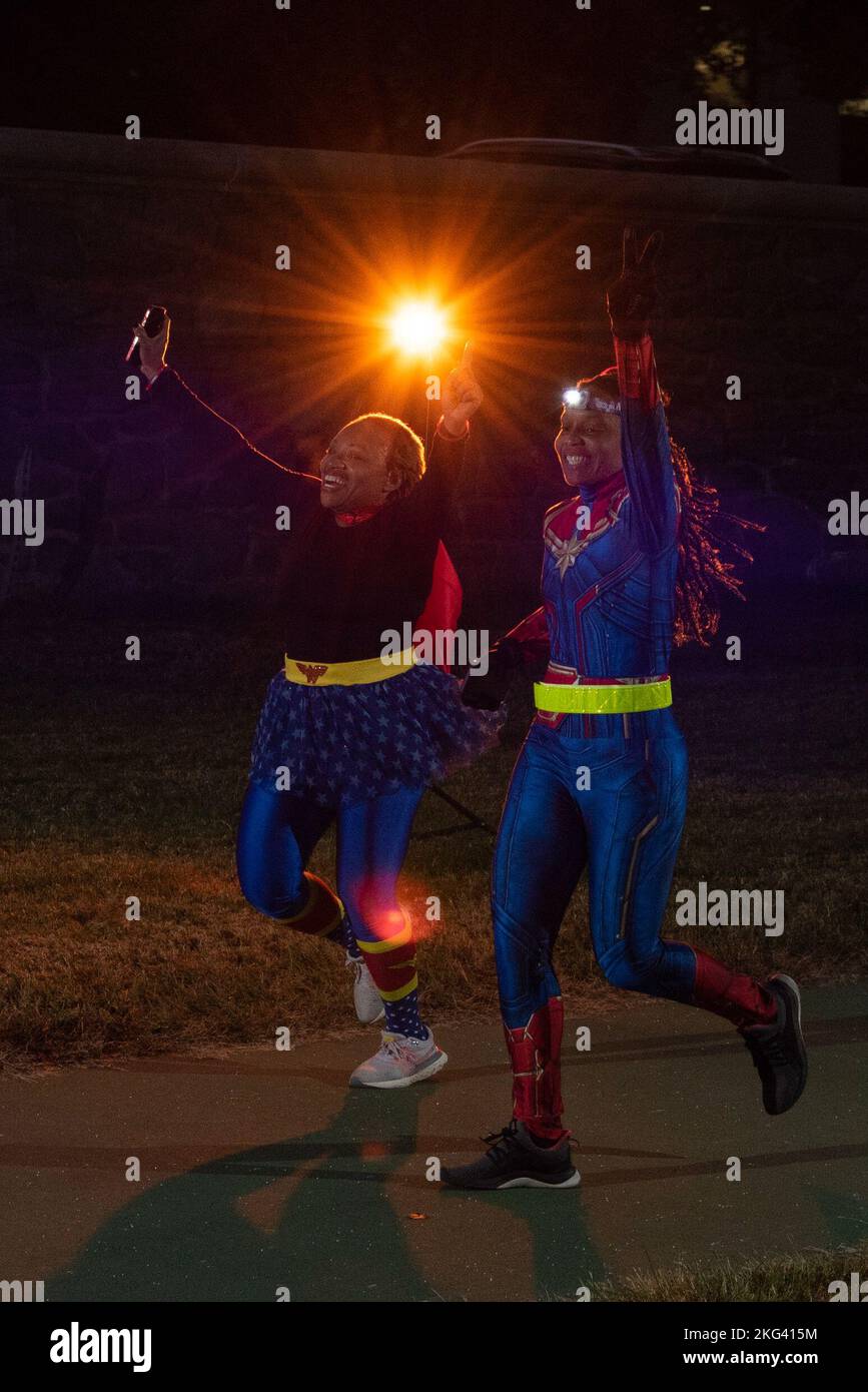 Sailors and Soldiers run in a Halloween 5K Run on the track in front of ...