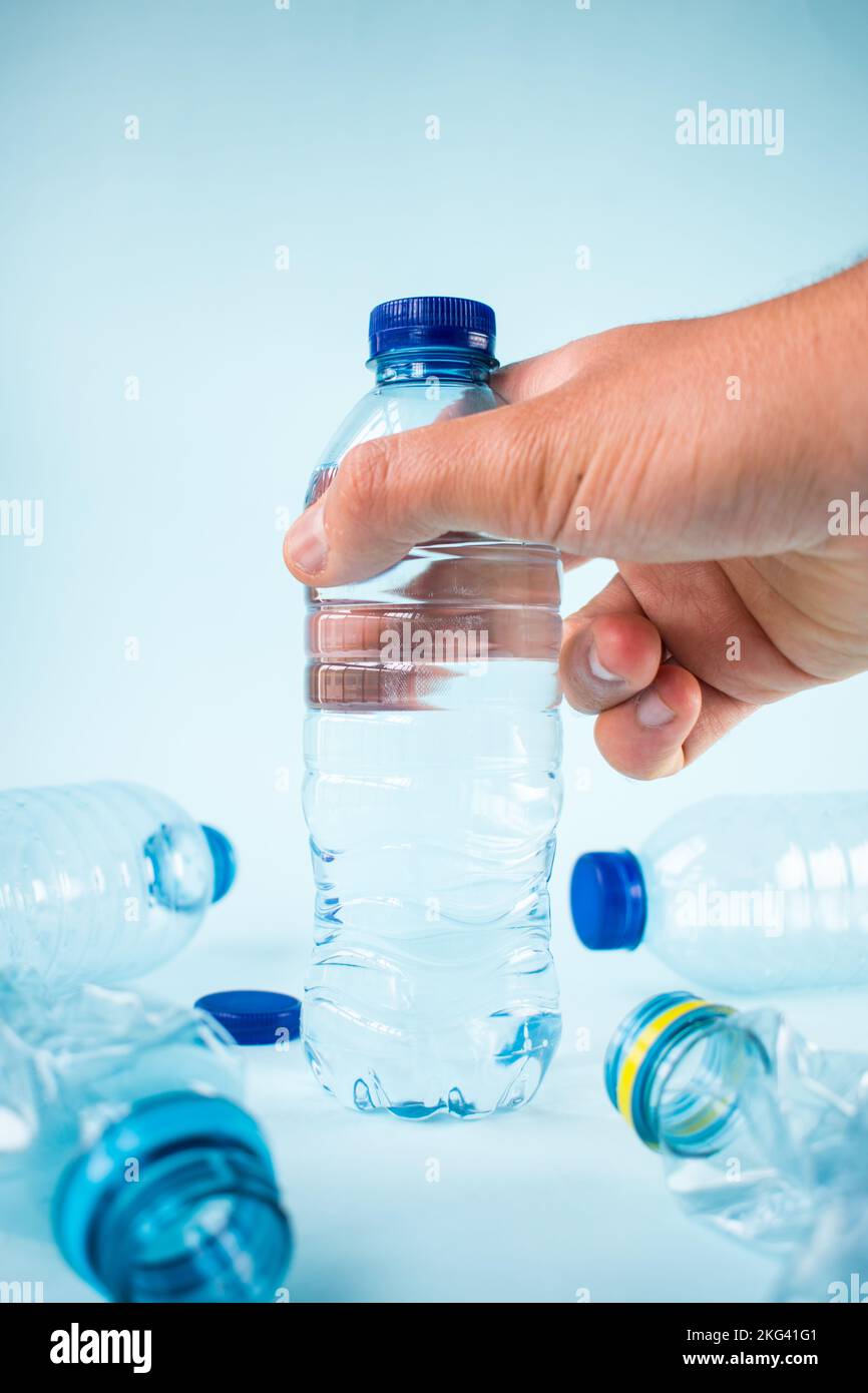 Hand taking water bottle and some other plastic bottles Stock Photo - Alamy