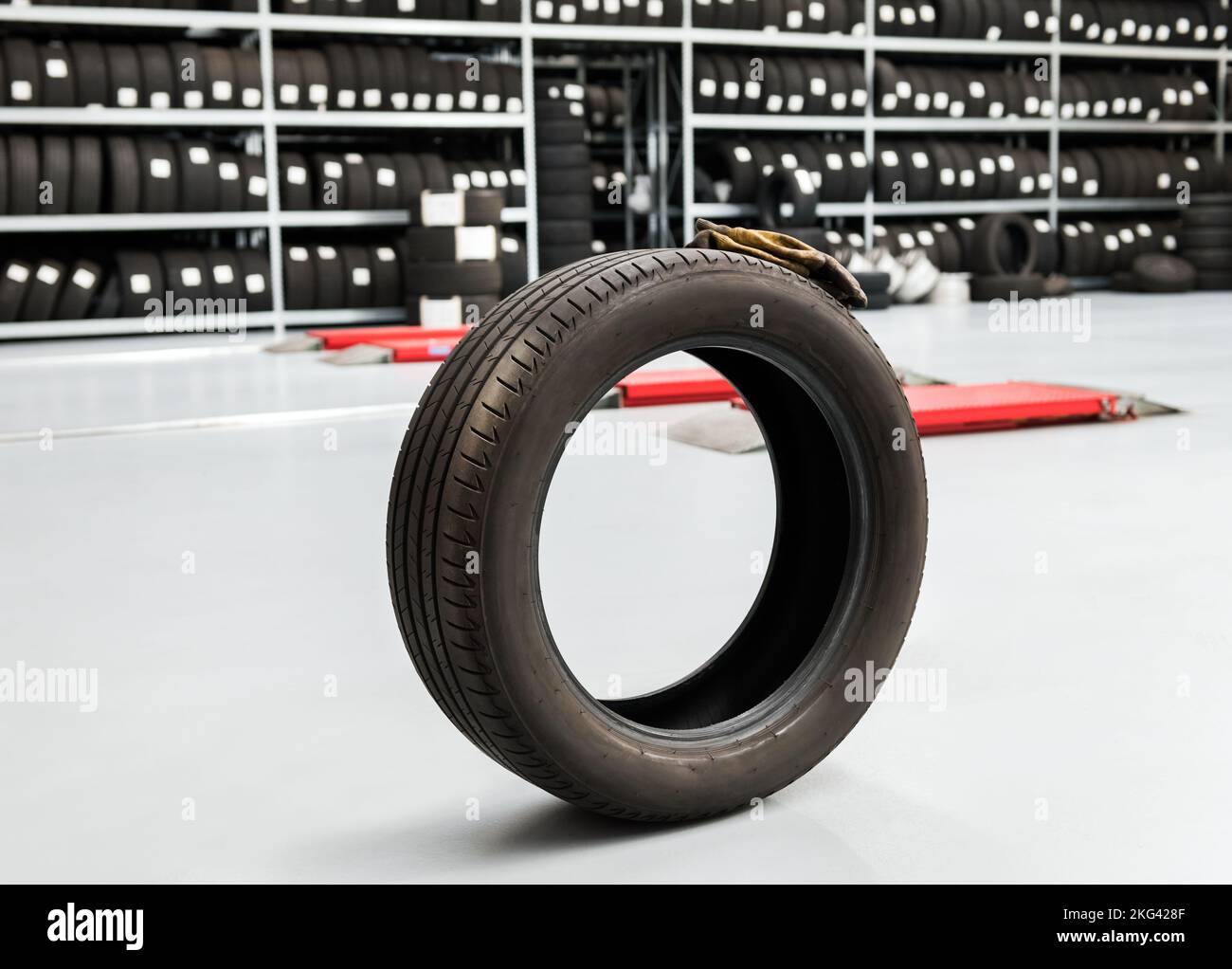 Tire placed on gray floor against shelves in spacious workshop of modern store Stock Photo - Alamy
