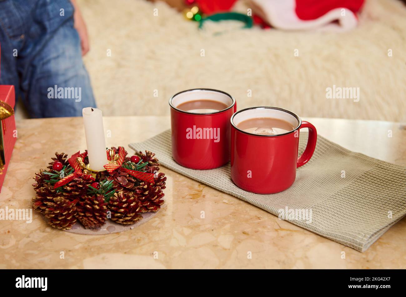 Red cups with hot cocoa drink on a green napkin, next to a decorative ...