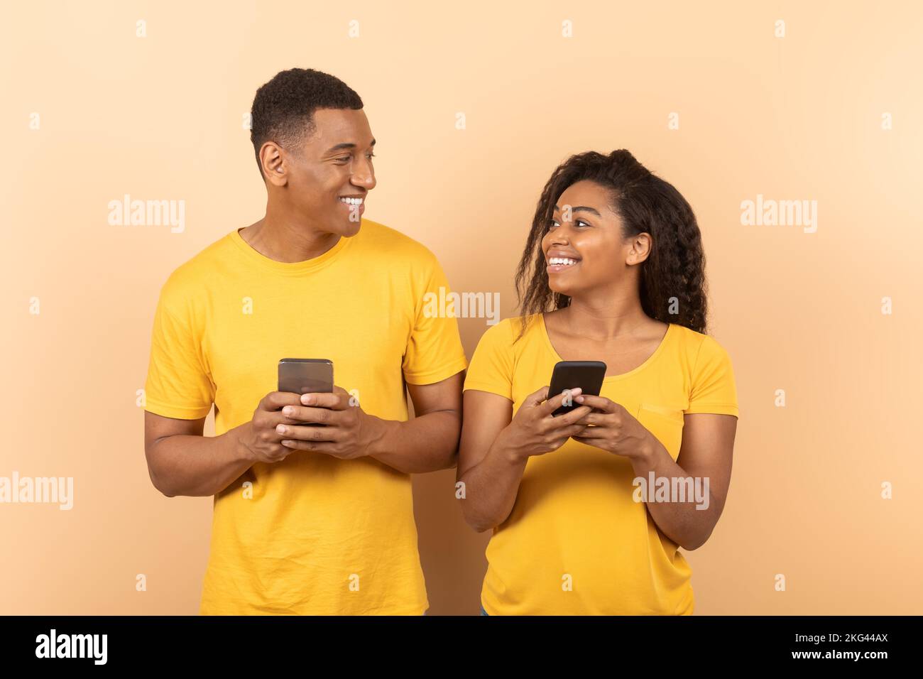Happy african american spouses using cellphones, networking or chatting ...