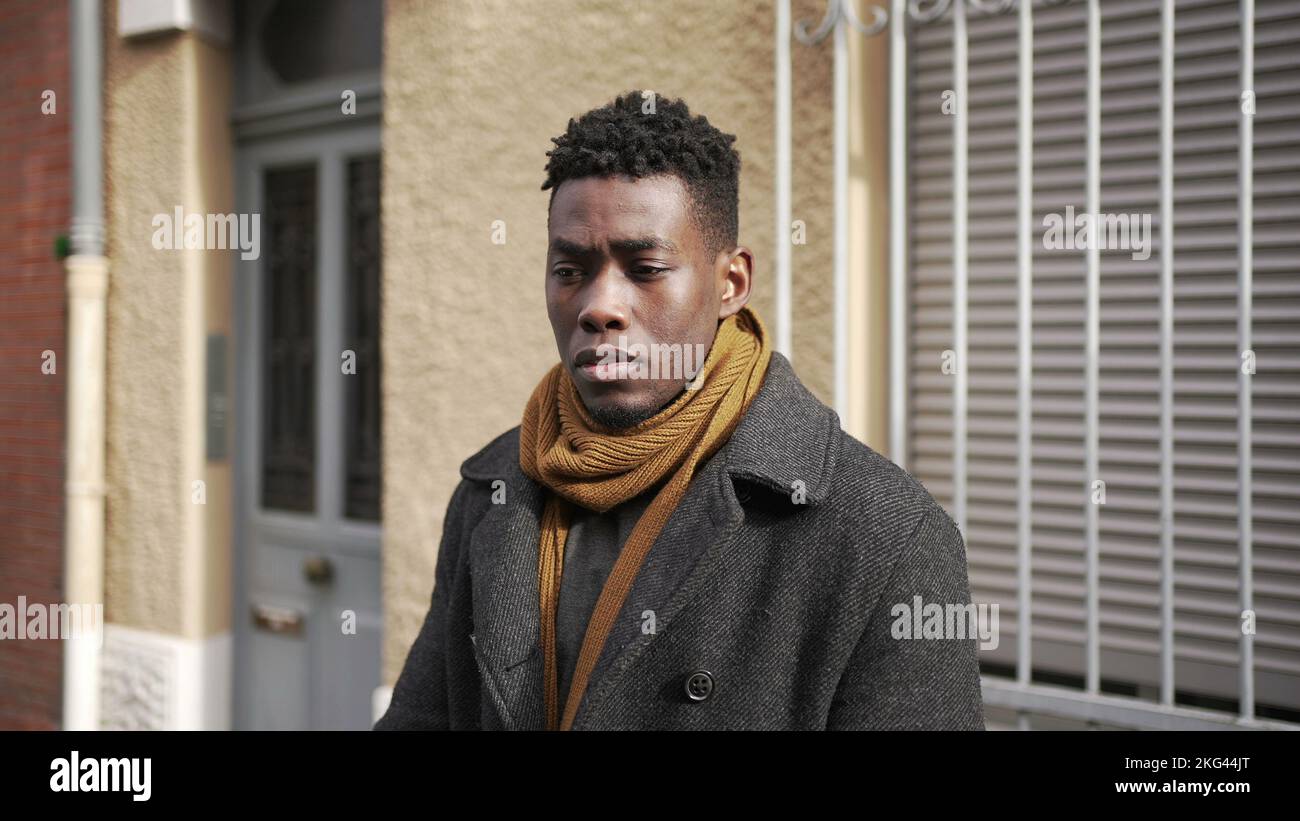 Pensive black man standing outside in city downtown. Thoughtful African ...
