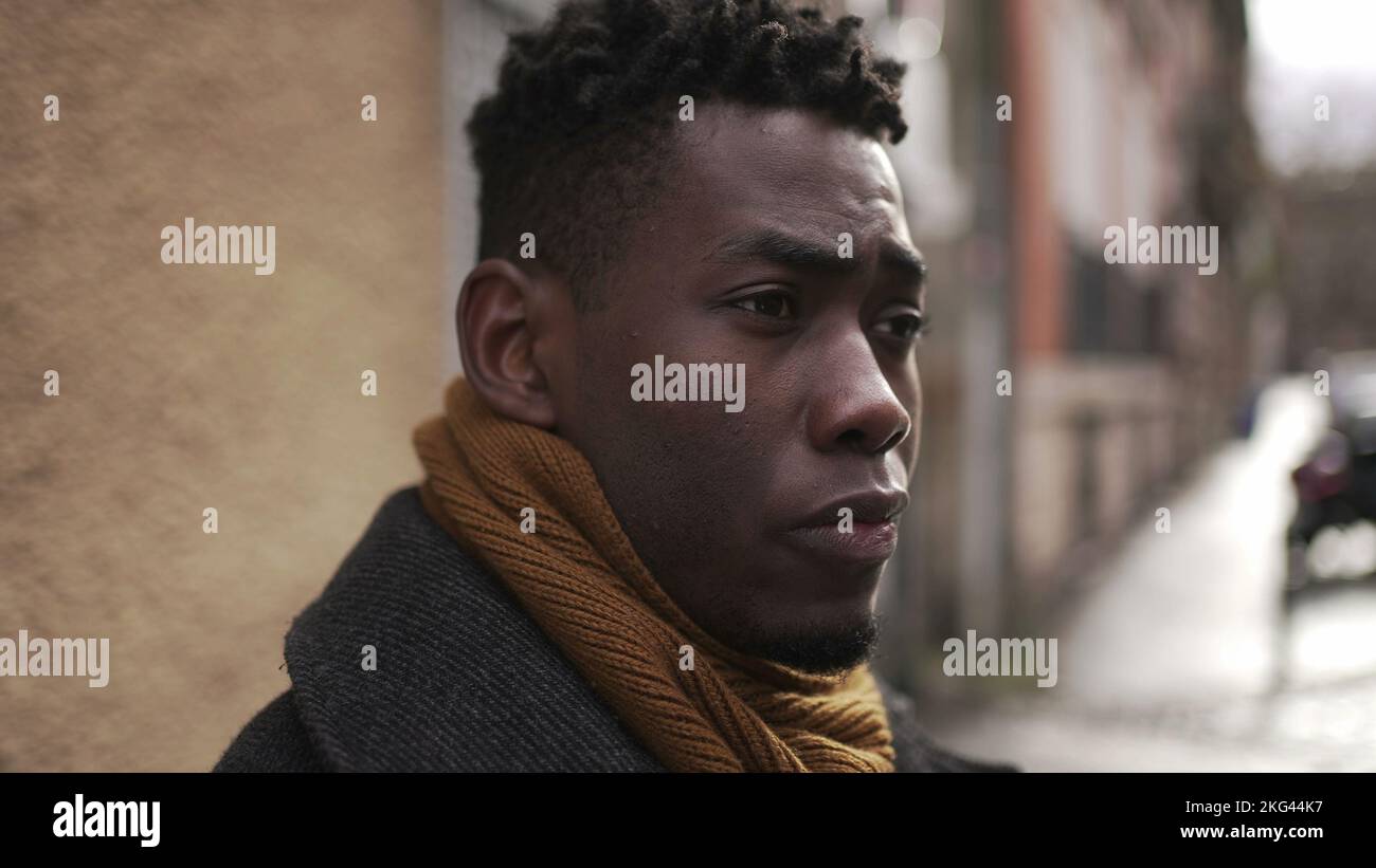 Pensive black man standing outside in city downtown. Thoughtful African ...
