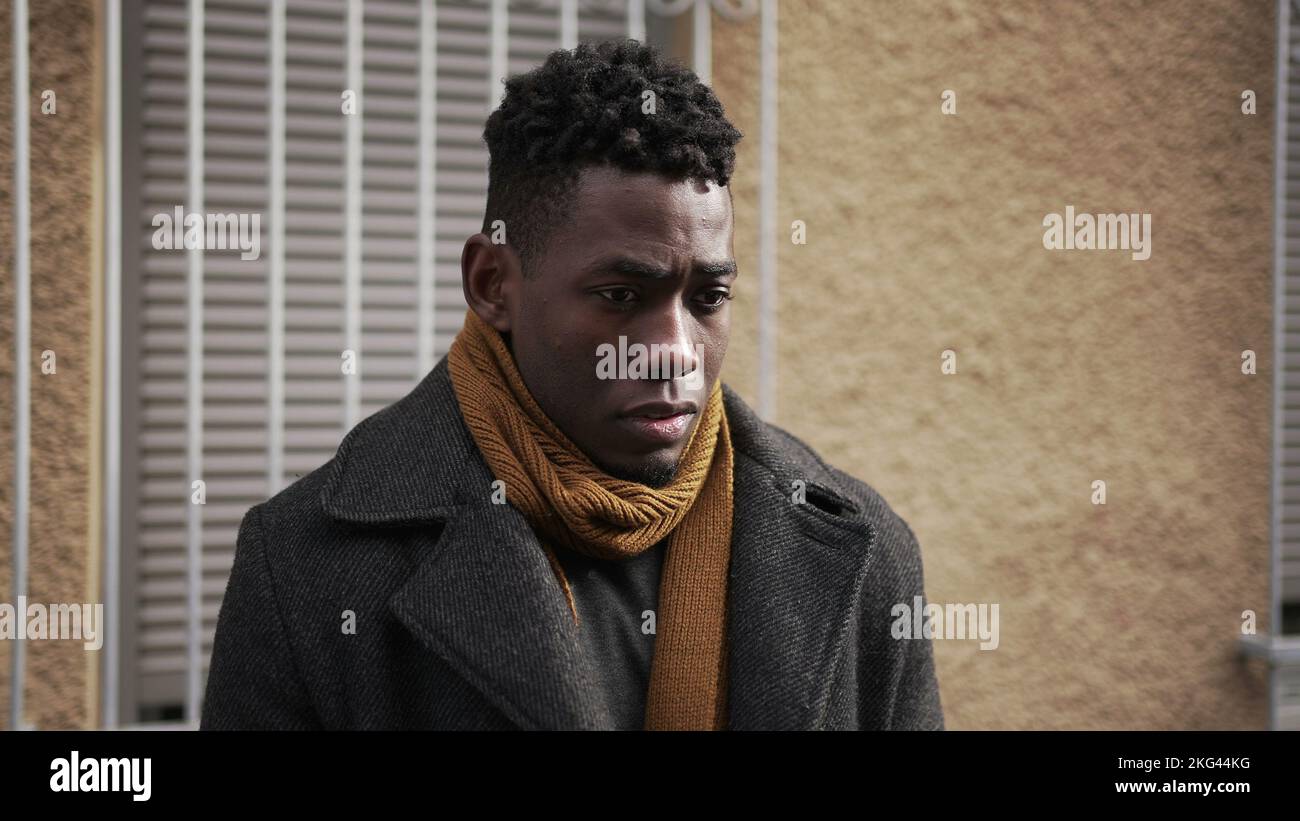 Pensive black man standing outside in city downtown. Thoughtful African ...
