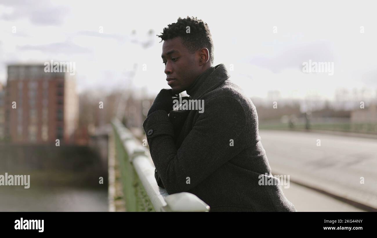Pensive black man thinking about life on top of city bridge. Elegant ...