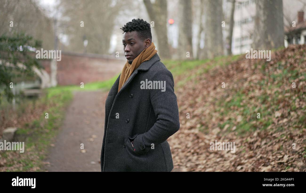 Pensive black man standing outside in cold winter season wearing scar ...