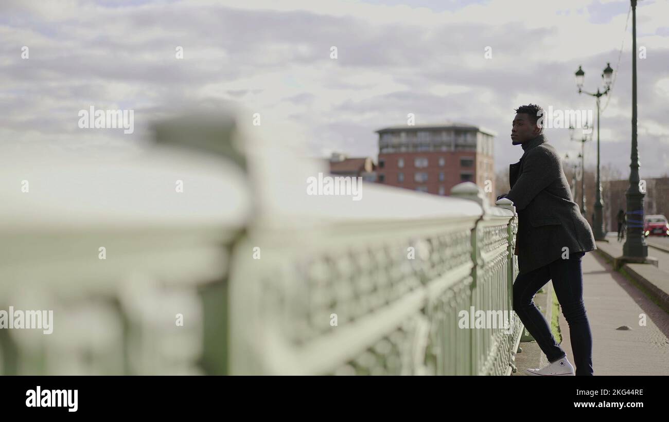 Pensive black man thinking about life on top of city bridge. Elegant ...
