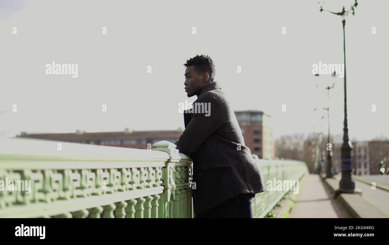 Pensive black man thinking about life on top of city bridge. Elegant ...