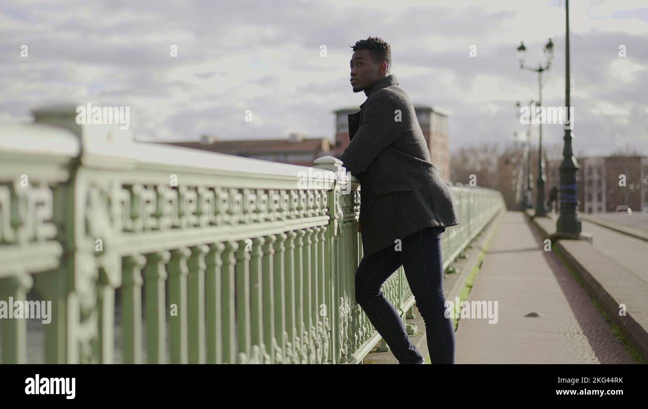 Pensive black man thinking about life on top of city bridge. Elegant ...