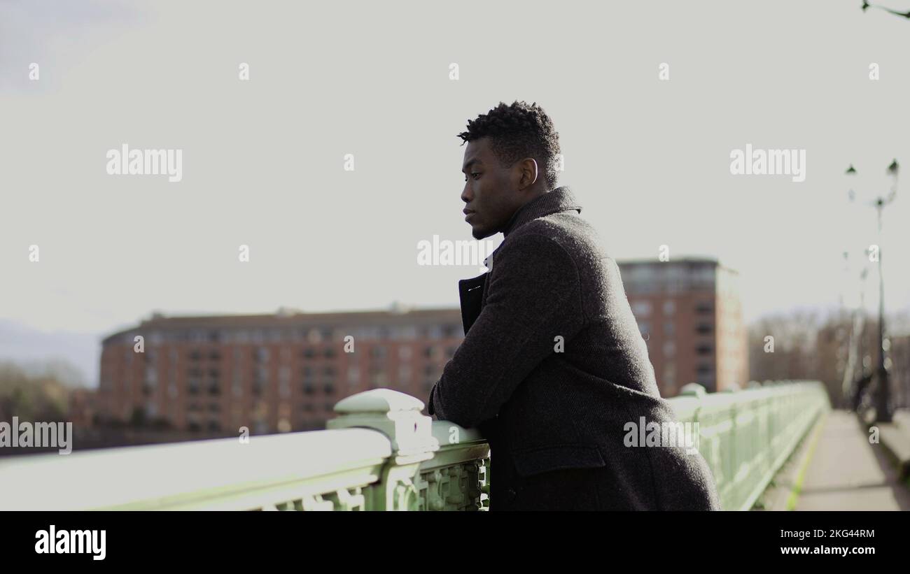 Pensive black man thinking about life on top of city bridge. Elegant ...