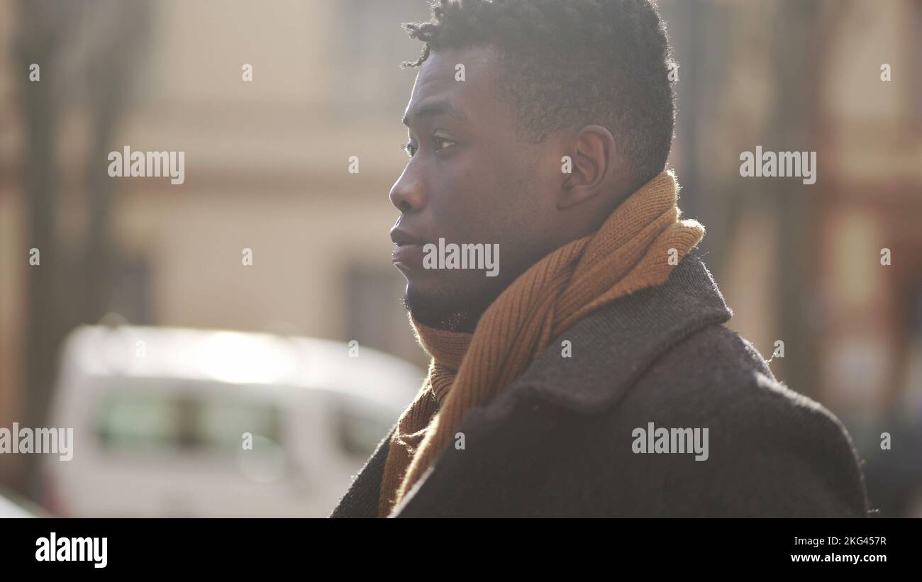 Pensive black man walking outside in city thinking by himself during ...