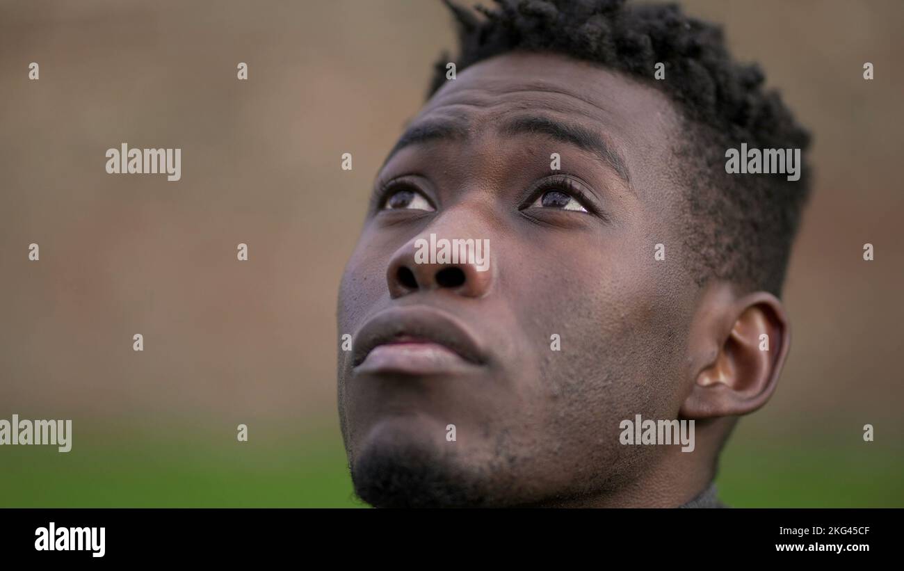 Pensive black African man looking at sky looking for hope Stock Photo ...