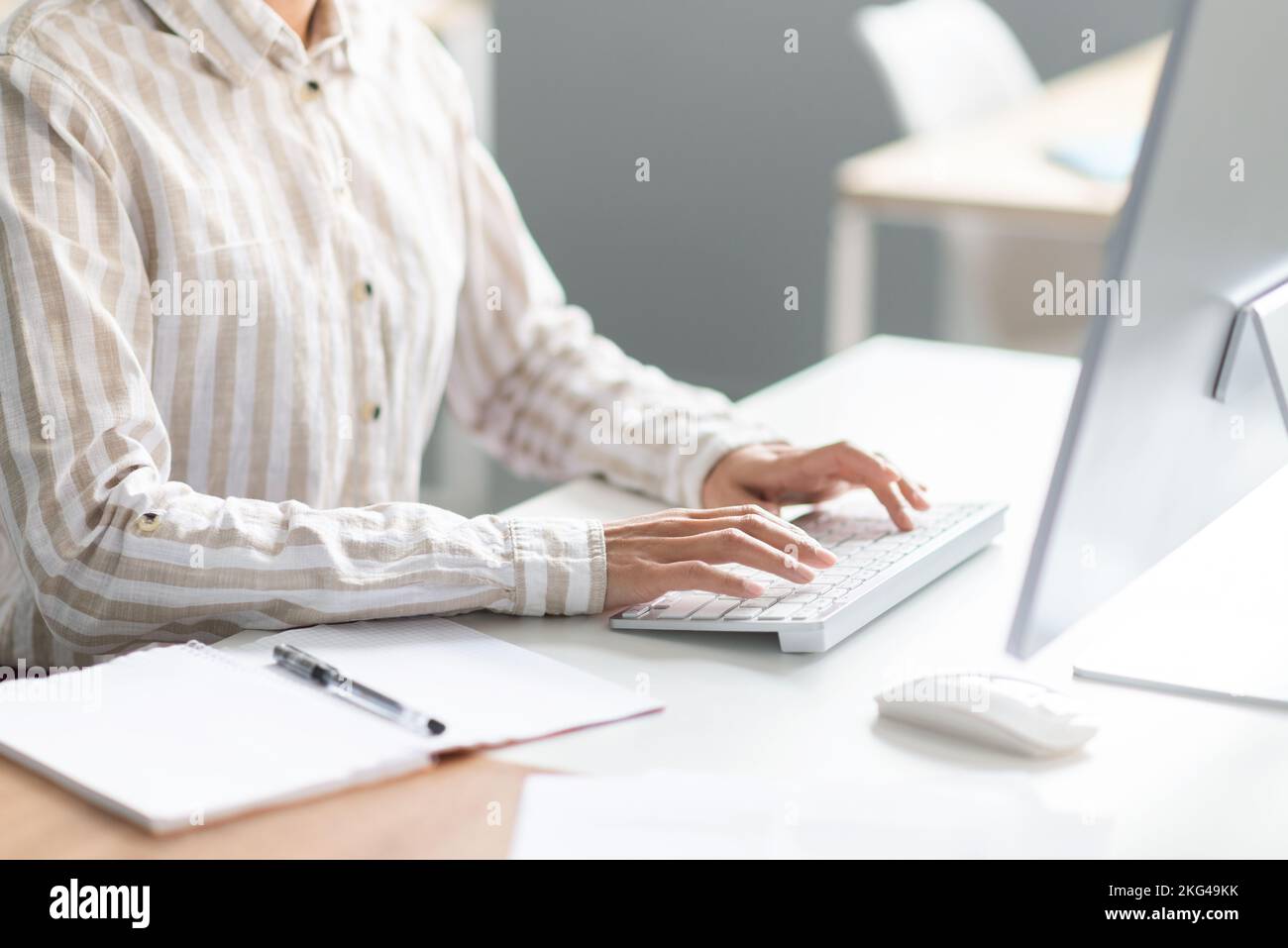 Unrecognizable female employee working on computer at desk in office ...