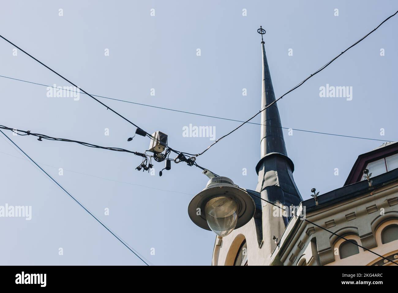 Close-up of street lights installed in x-shaped wires under a blue sky ...