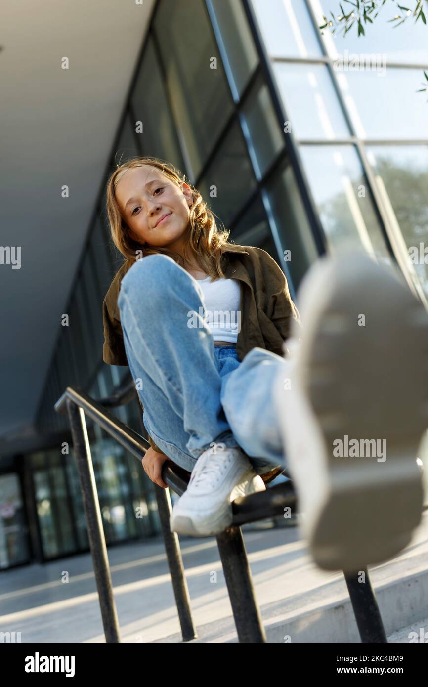 Creative portrait of teenage girl sitting on stairs, urban street ...