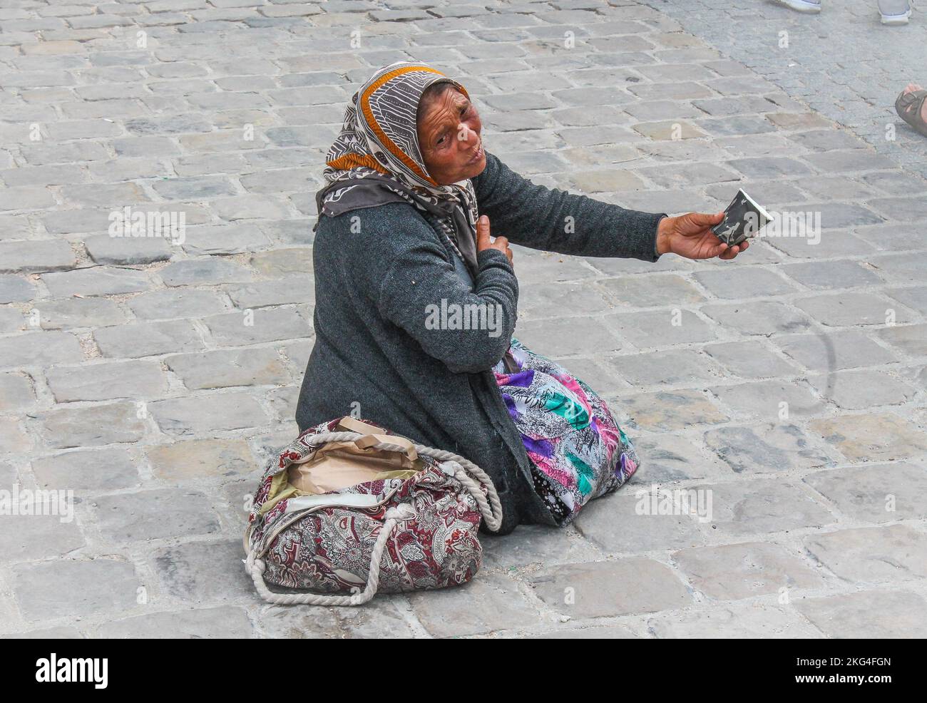 An older homeless female begging for money in the streets of Greensboro ...
