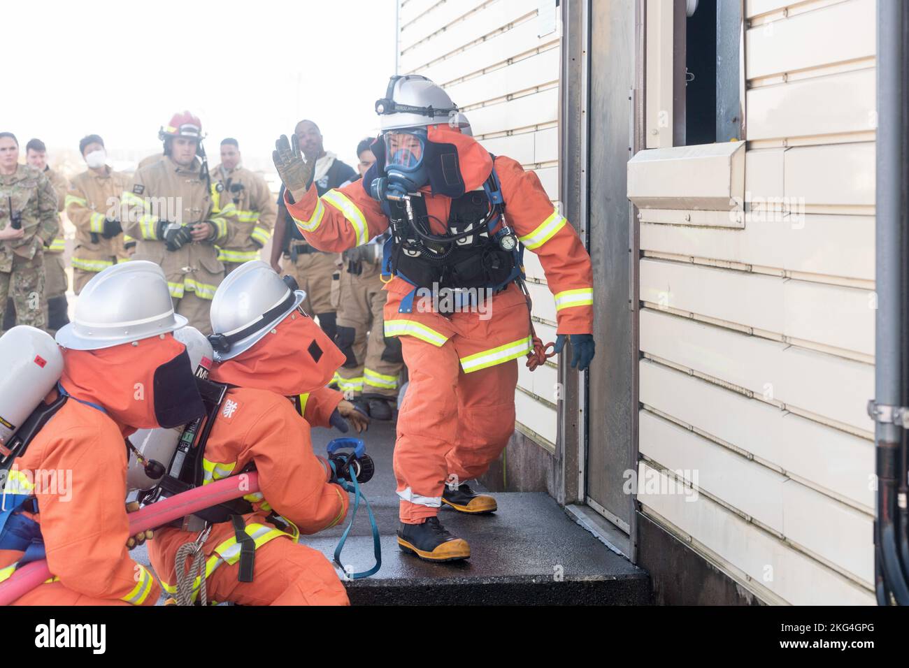 A firefighter with the Japanese Air Self-Defense Force gives hand ...