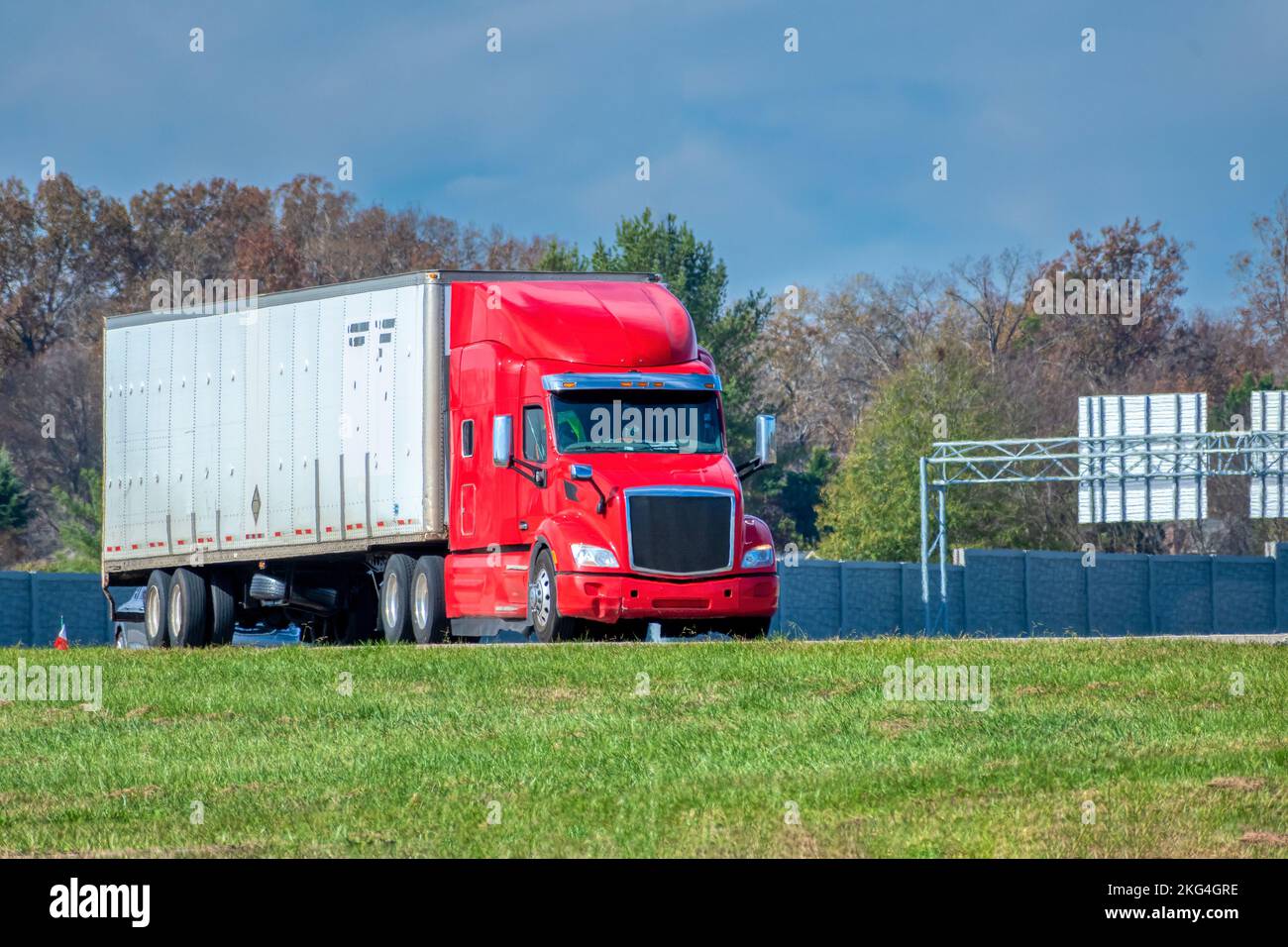 Horizontal shot of a red and white eighteen wheeler exiting from an ...