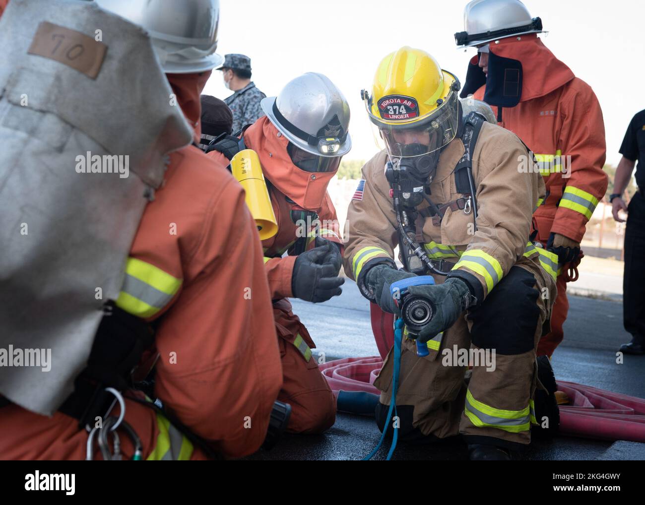 A firefighter with the Japanese Air Self-Defense Force, left, teaches ...