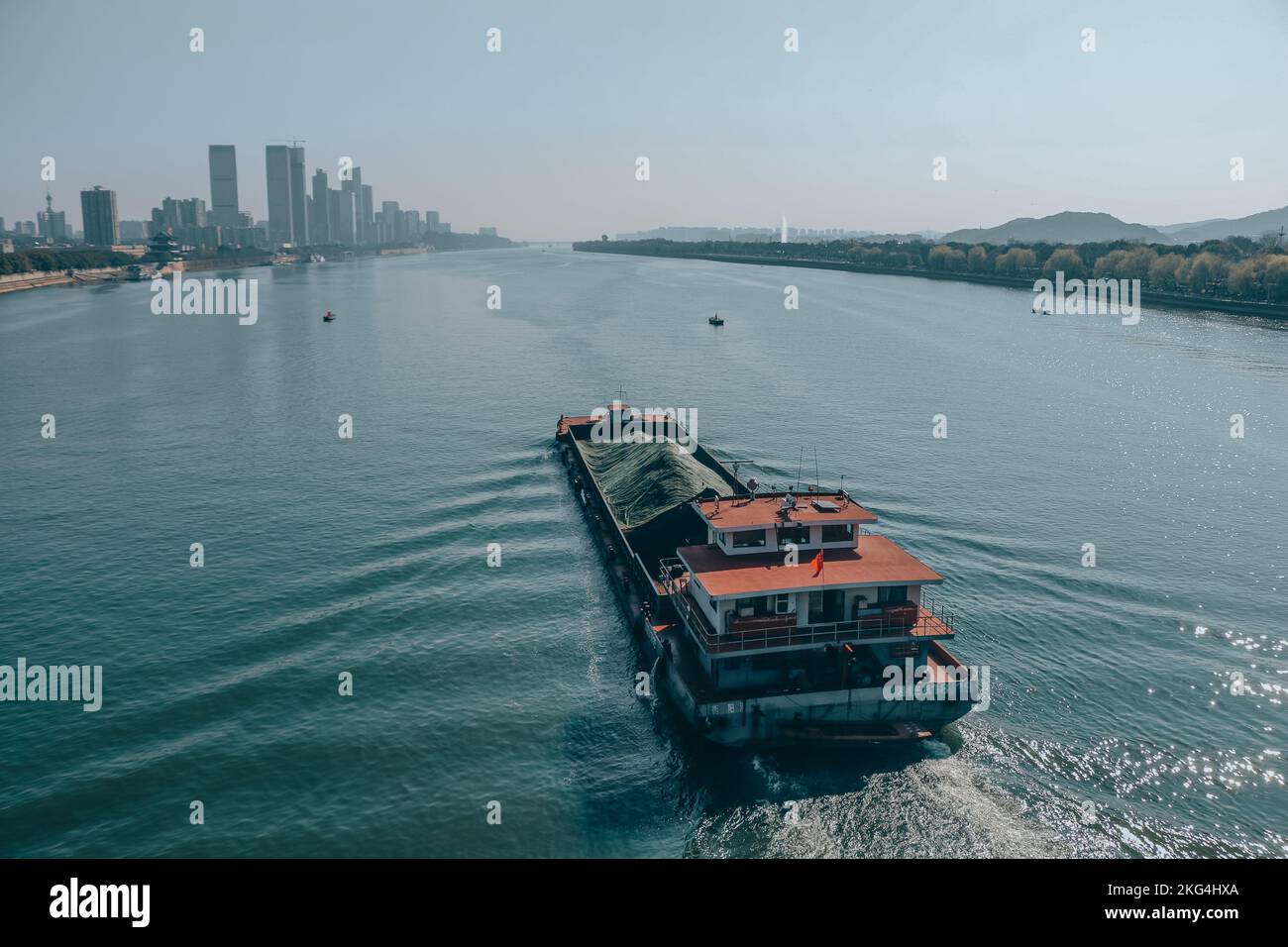 A long boat in a river with a background of a city skyline Stock Photo ...
