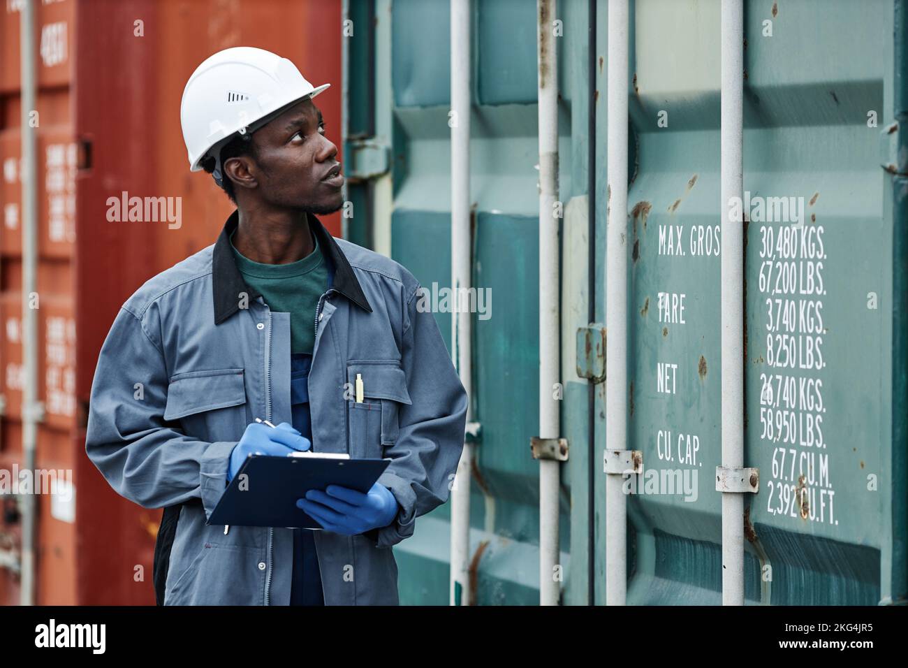 Waist up portrait of young black man wearing hardhat while working at ...