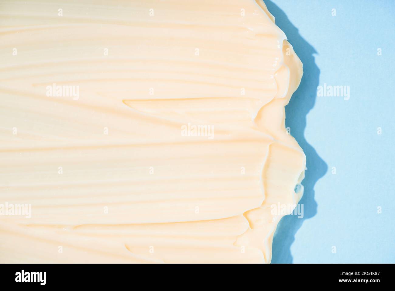 Silky cream texture over blue as background with copy space. Vanilla ...