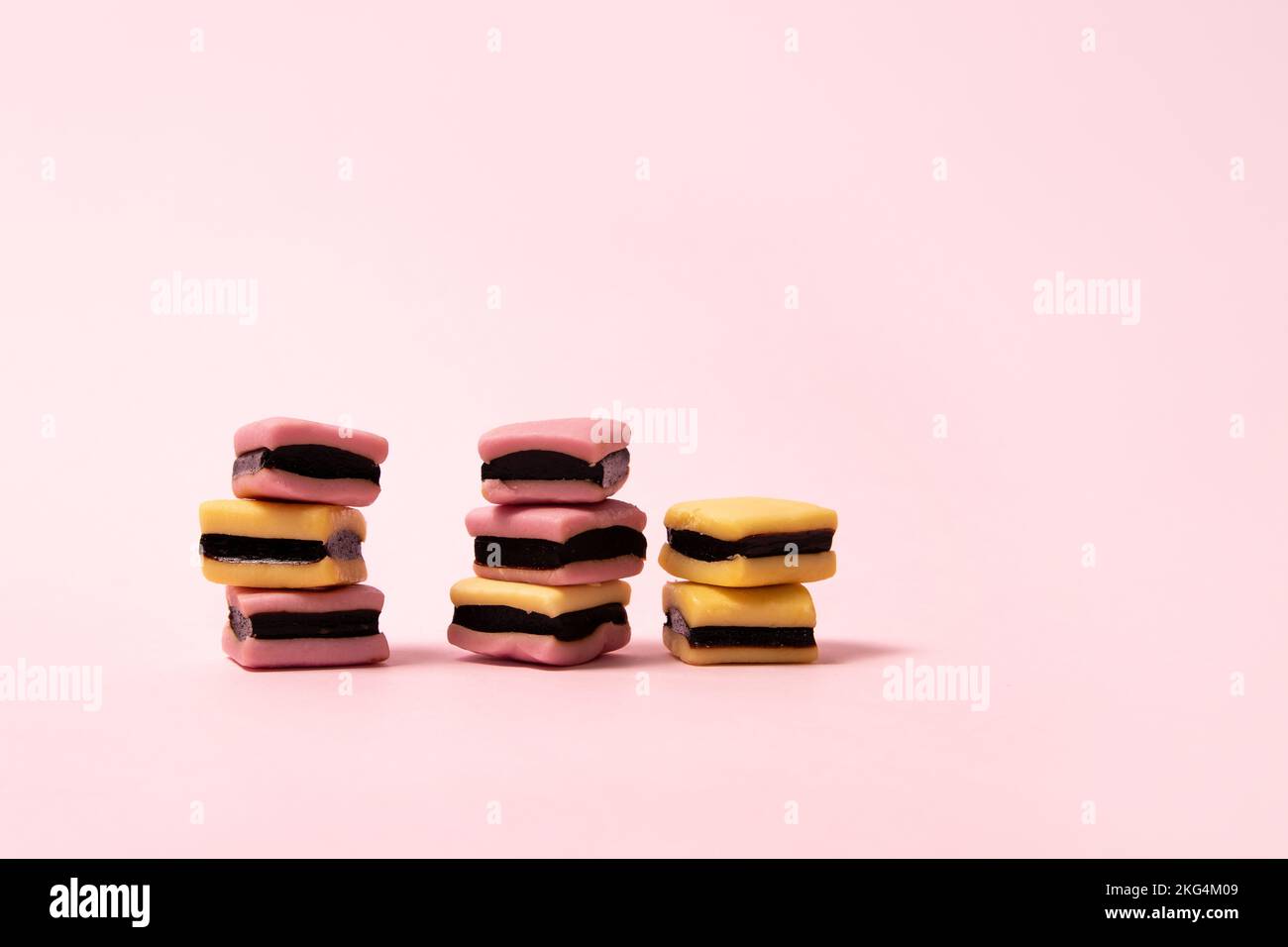 Piles of pink and yellow licorice candies on pink background Stock ...