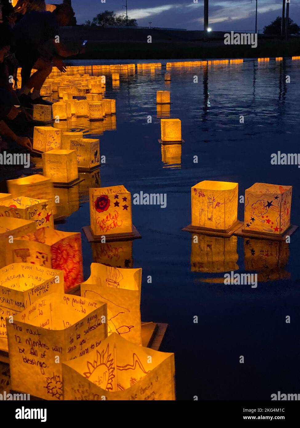 A vertical of paper lanterns floating on a river during the water ...