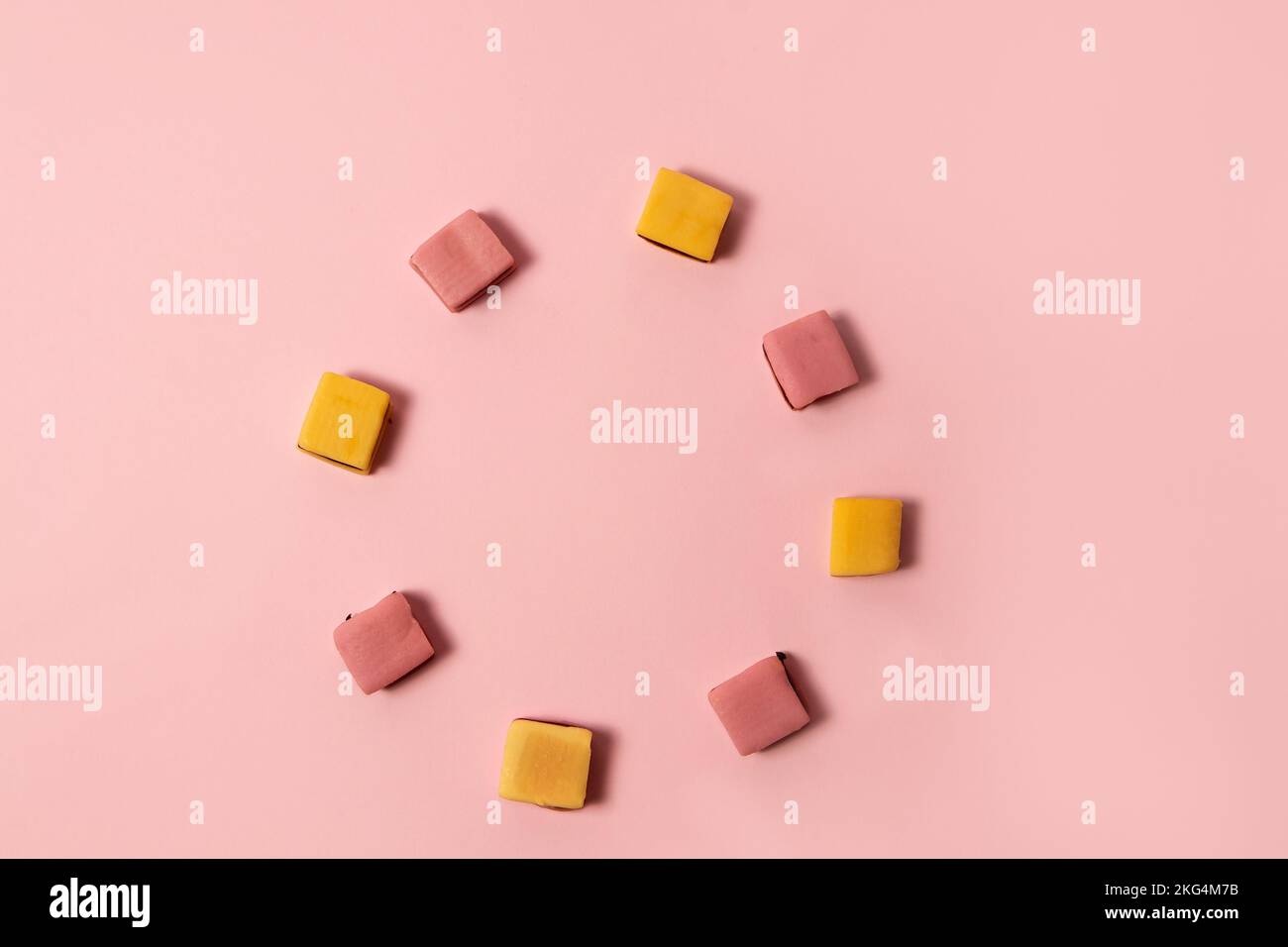 Circle of pink and yellow licorice candies on pink background Stock ...
